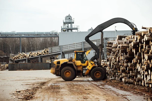 front loader for loading timber. an industrial tractor transports ...