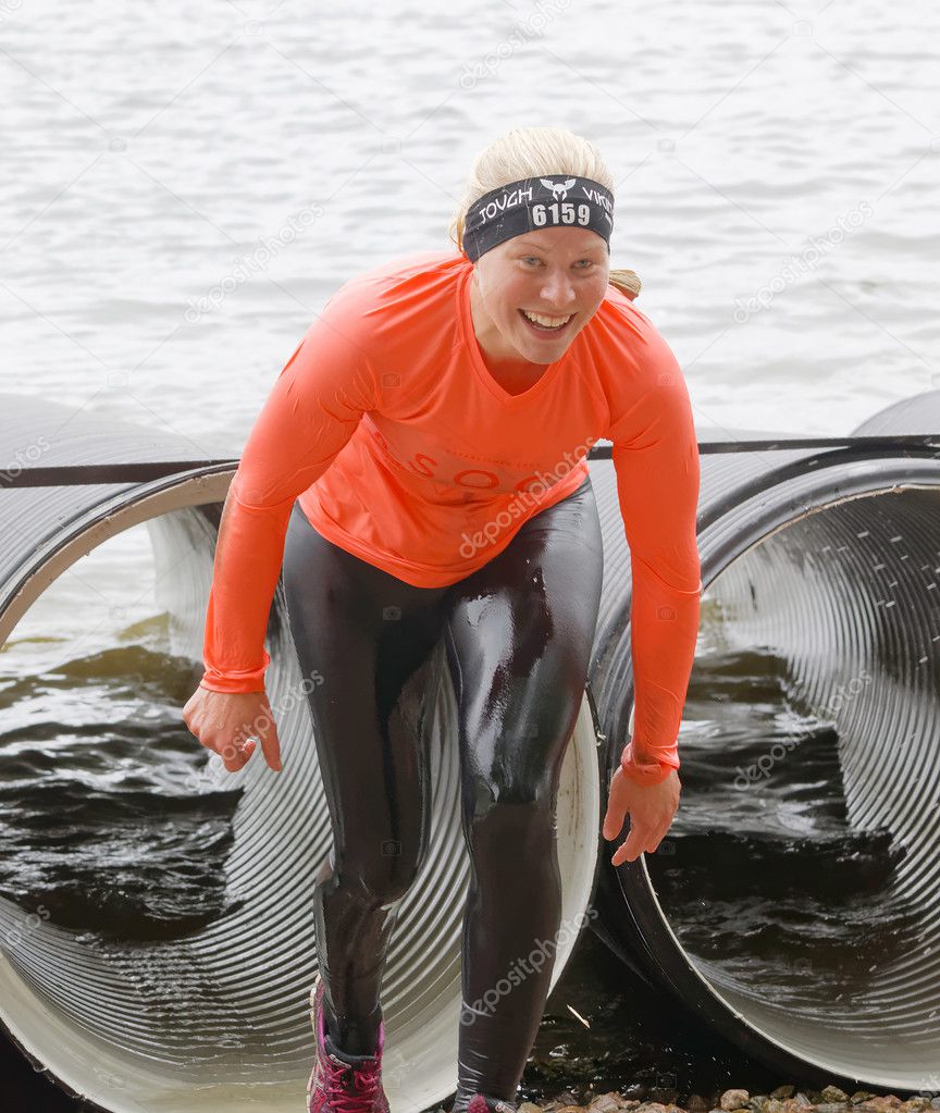ESTOCOLMO, SUECIA - 14 DE MAYO DE 2016: Mujer sonriente saliendo de un obst culo de tubo en la ...