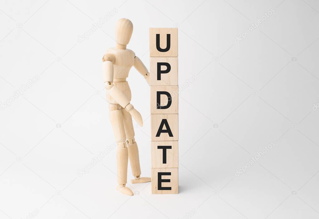 Maniqu de madera cerca de la torre de cubos con actualizaci n de la palabra en la mesa contra el ...