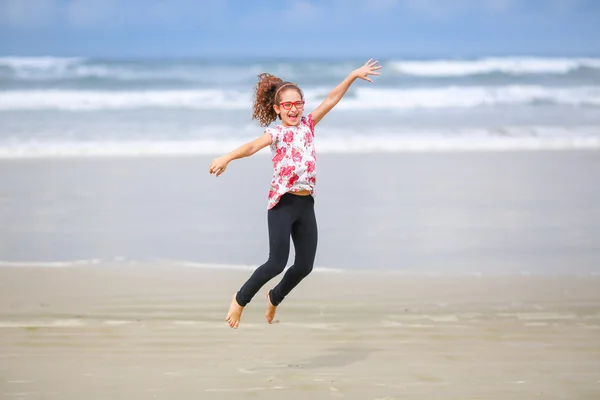 Girl jumping on the beach Stock Photo by ©FCastello 112196346