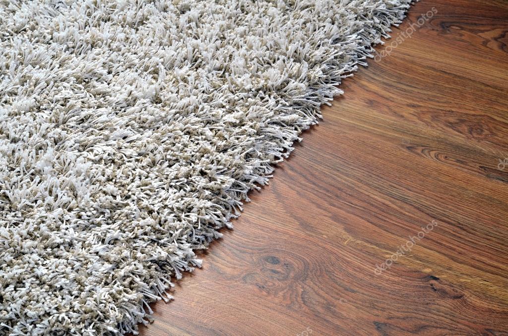White shaggy carpet on brown wooden floor Stock Photo by ©cobraCZ 67261057