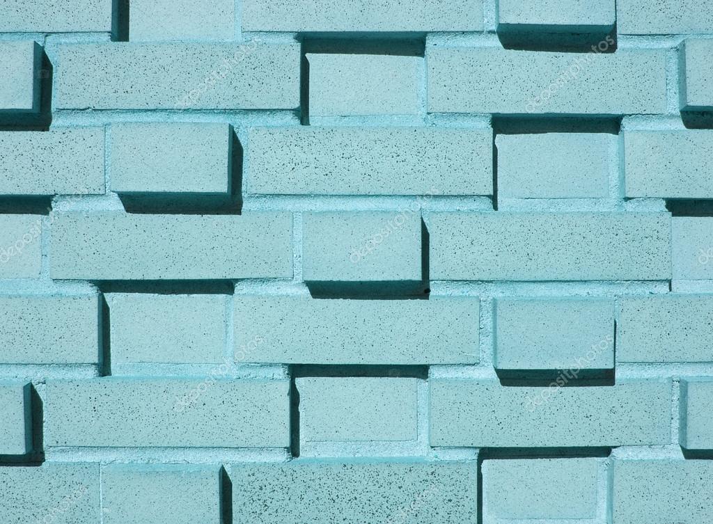 A pastel blue, teal or aqua multi-layered and multi-sized brick wall ...