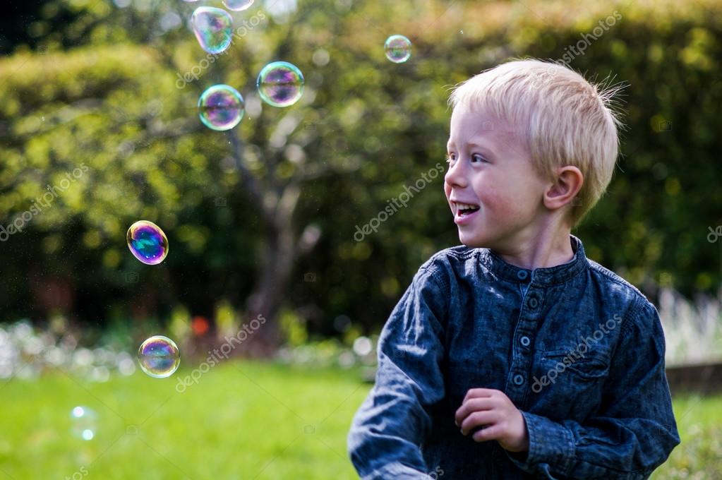 One Little boy blows soap bubbles in the garden on a summer day Stock ...