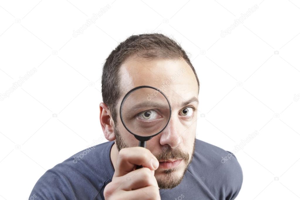 Astonished man looking through a magnifying glass Stock Photo by ...