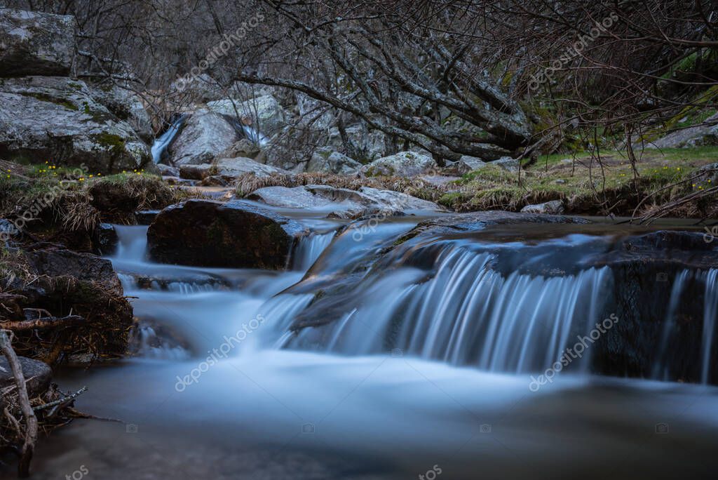 El agua fluye entre las rocas y forma pequeñas cascadas, Rascafria ...