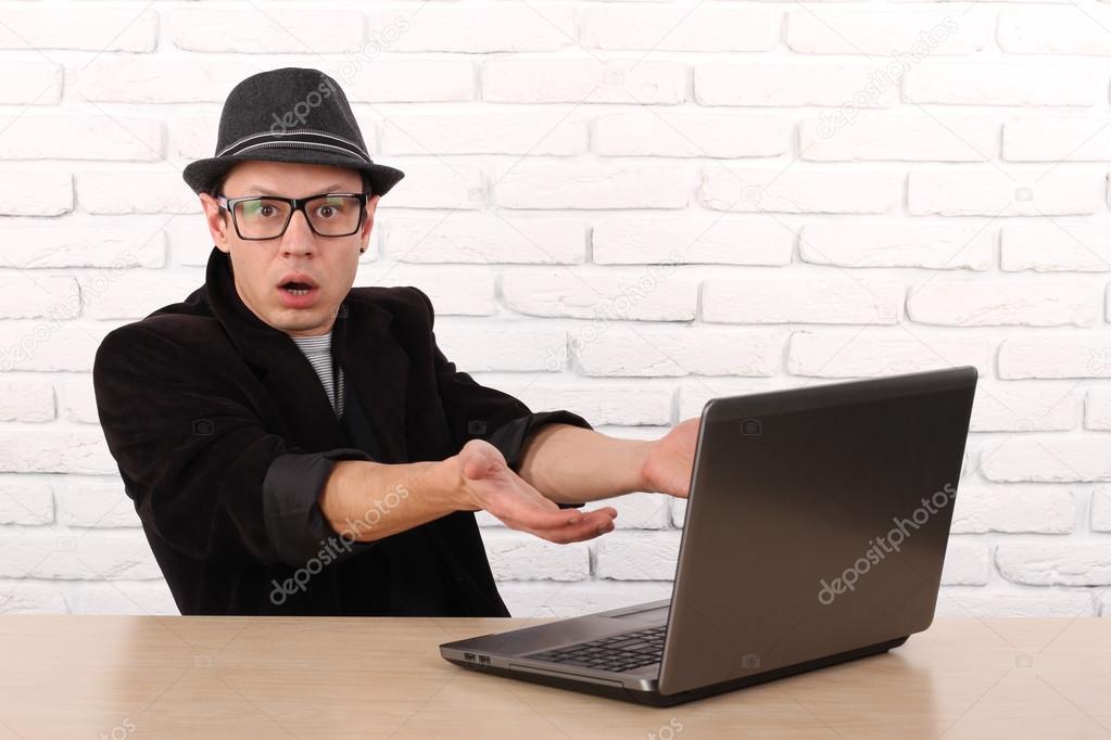 Shocked young business man using laptop looking at computer screen ...