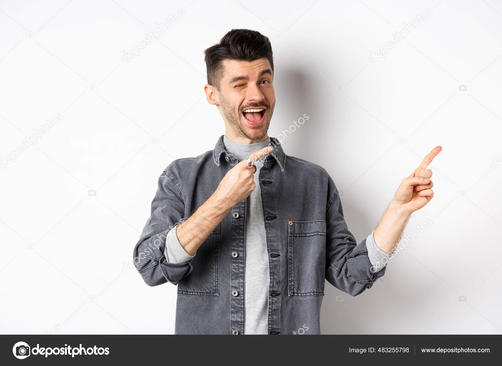 Handsome smiling guy making announcement, winking and pointing at upper ...