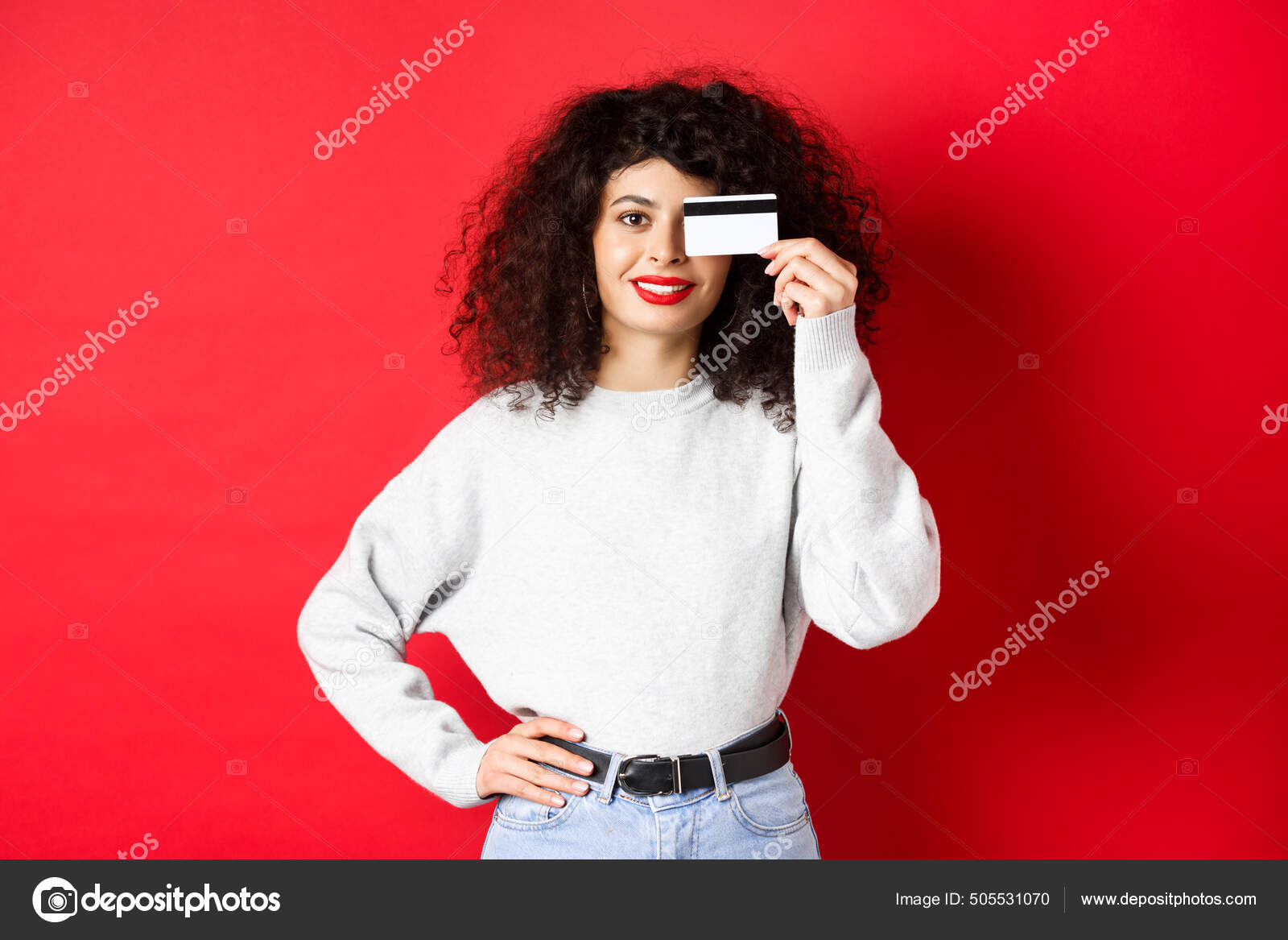 Beautiful female model with curly hair, showing plastic credit card and ...