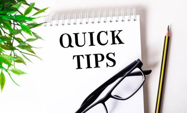 QUICK TIPS is written in a white notebook next to a pencil, black ...