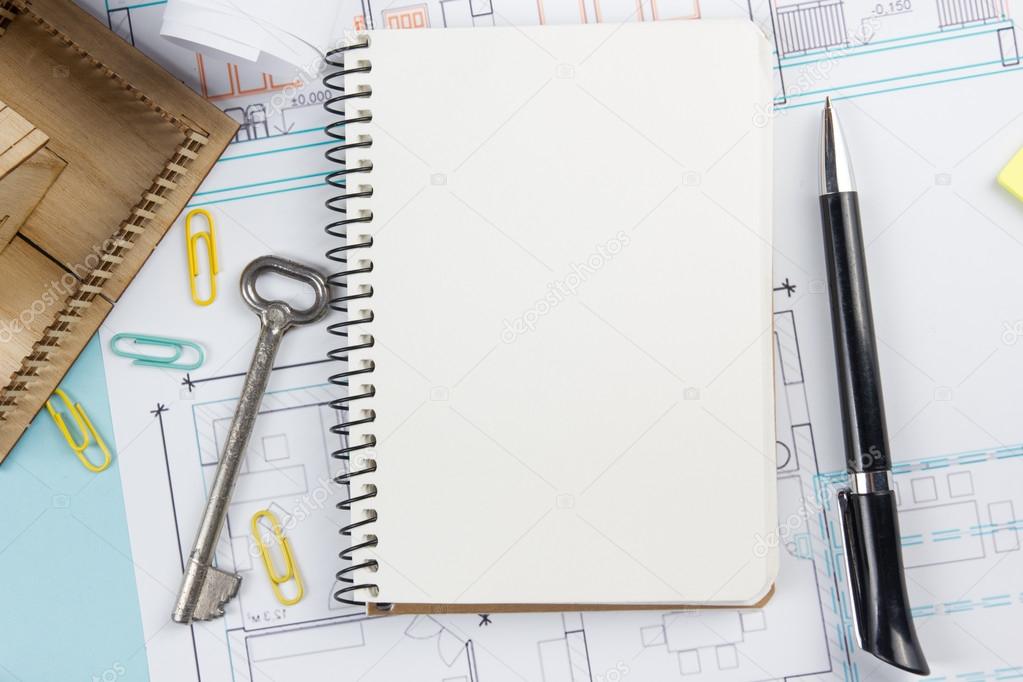 Real estate concept. Blank white notebook on architectural desk table ...