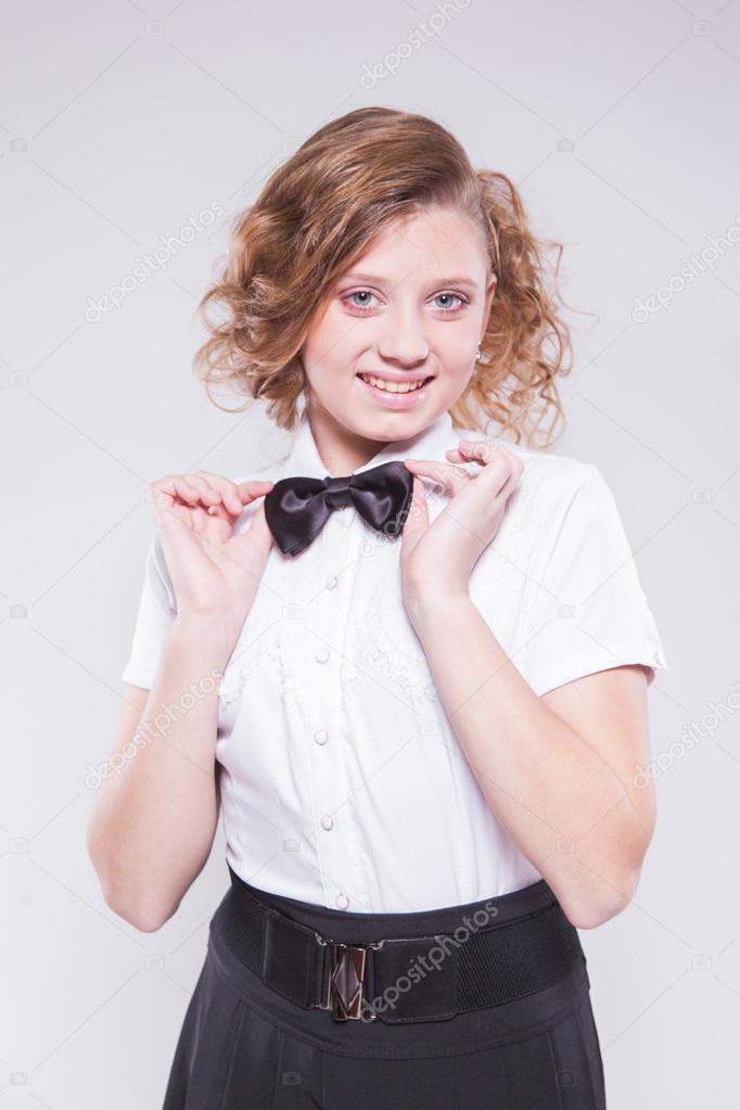 Girl in a white shirt and bow tie looks at the camera and smilin Stock ...