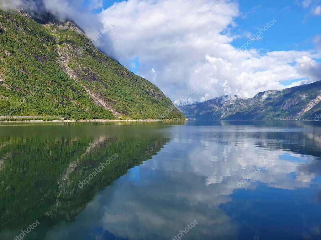 reflejo del cielo y las montañas en el agua azul del fiordo - Eidfjord 2023