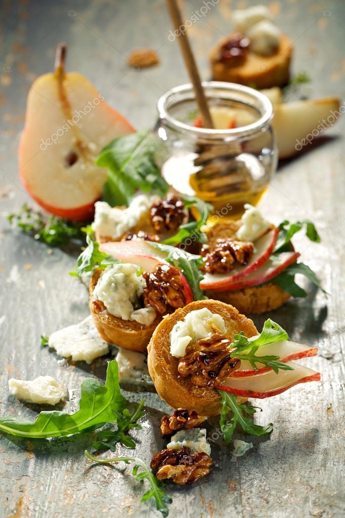 Canapes with blue cheese, fresh pear, honey, caramelized walnuts and ...