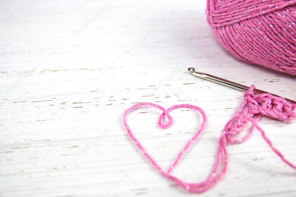 Pink crochet background with yarn heart Stock Photo by ©fieldwork 54881043
