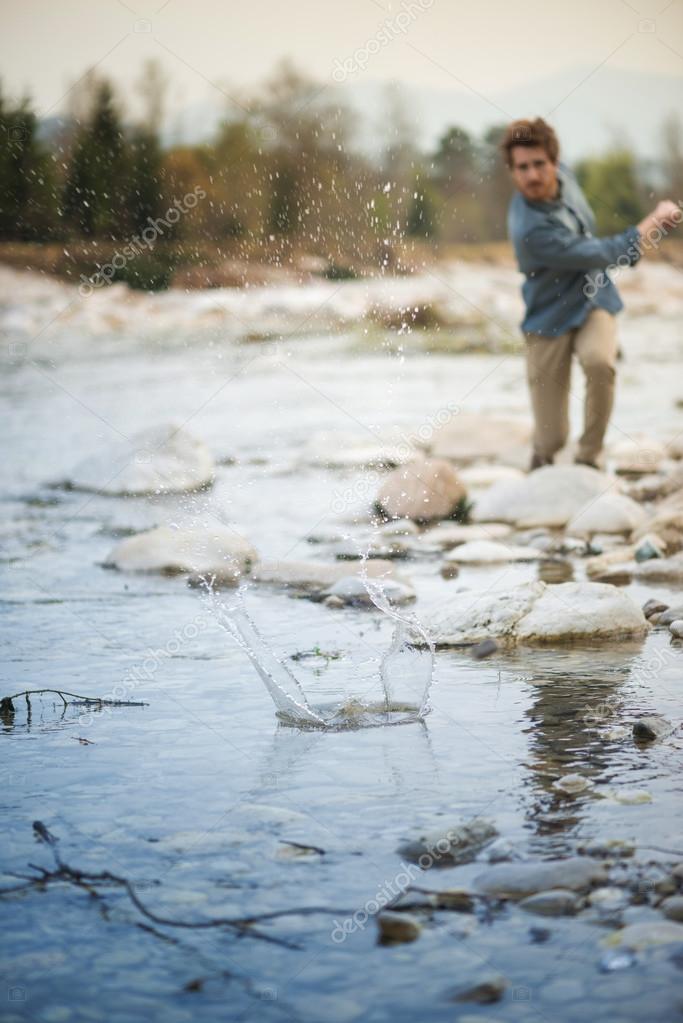 Hombre arrojando piedras en el río: fotografía de stock © stockasso ...