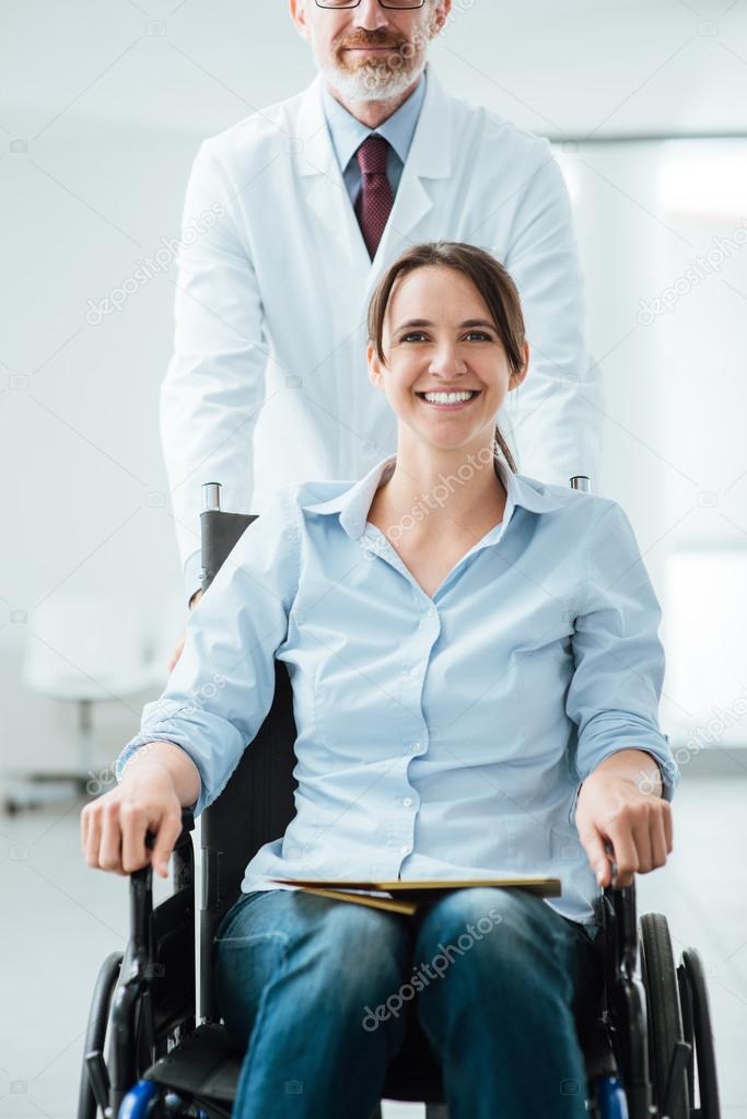 Doctor pushing a patient in wheelchair — Stock Photo © stockasso #78556224