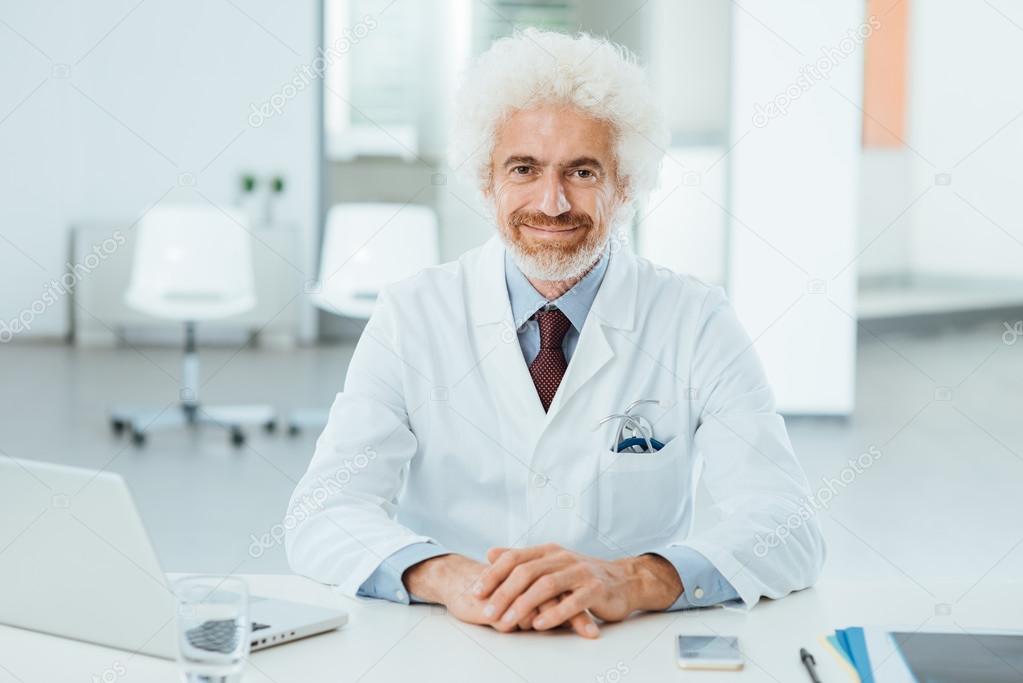 Doctor at desk posing Stock Photo by ©stockasso 80149410