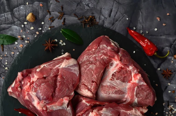 Fresh raw mutton shoulder meat isolated on black stone background with ...