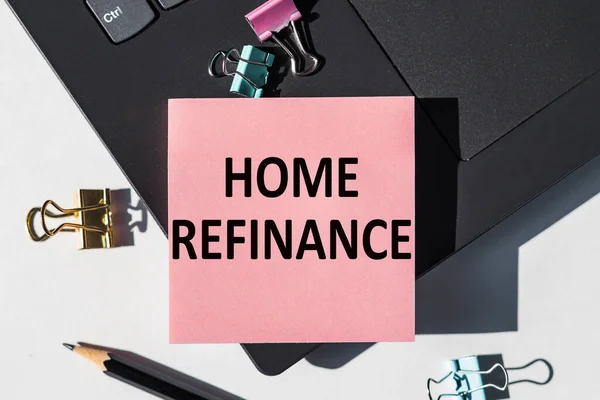 HOME REFINANCE note is written on a paper sticker on a laptop keyboard ...