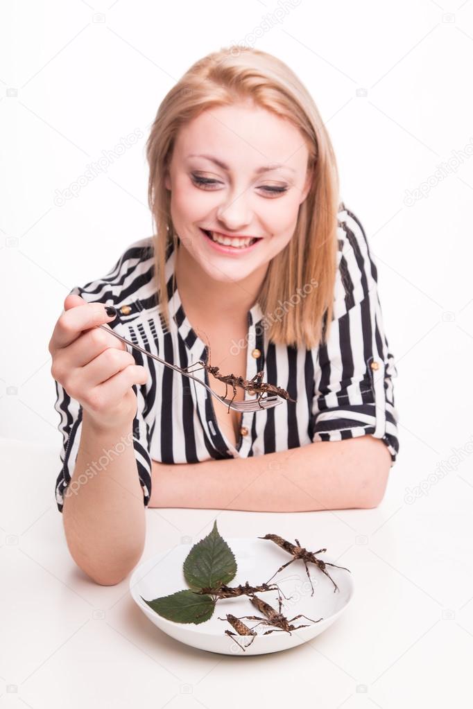 Woman eating insects in restaurant Stock Photo by ©MichalLudwiczak 82070138