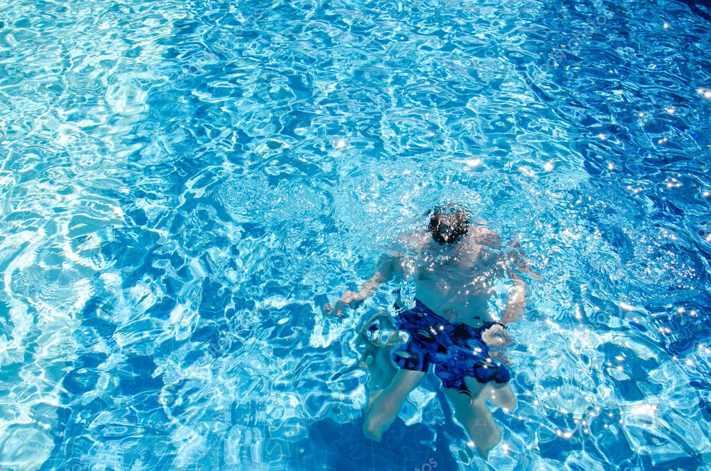 Hombre Caucásico En Bañador Bucea Bajo El Agua En La Piscina Con Azulejos Azules De Vacaciones