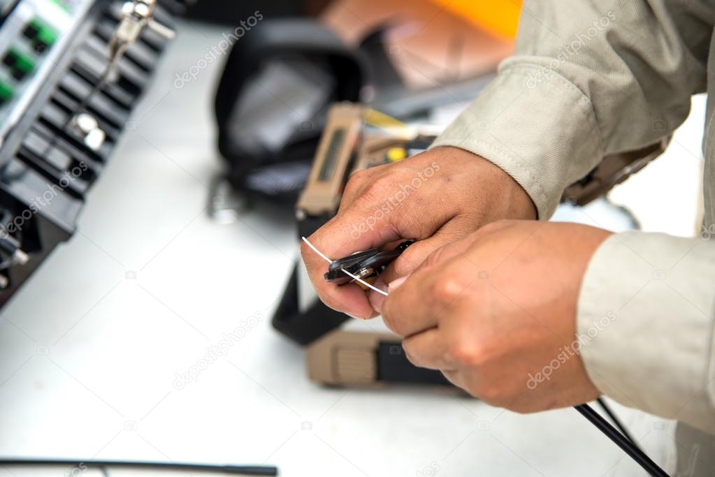 Technicians cutting fiber optic cables. Stock Photo by ©poungsaed 117837020