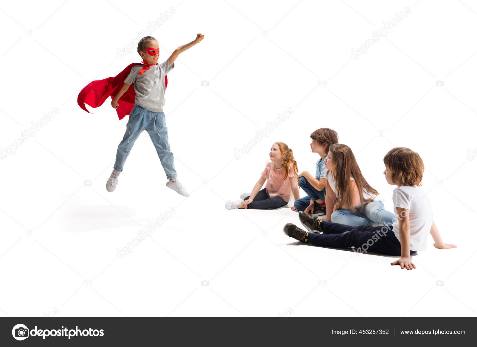 Child pretending to be a superhero with her friends sitting around ...
