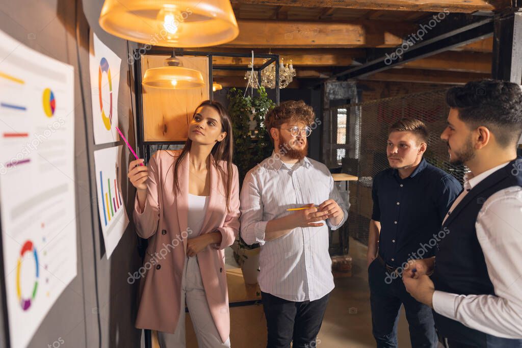 Colegas trabajando juntos en la oficina moderna utilizando dispositivos ...