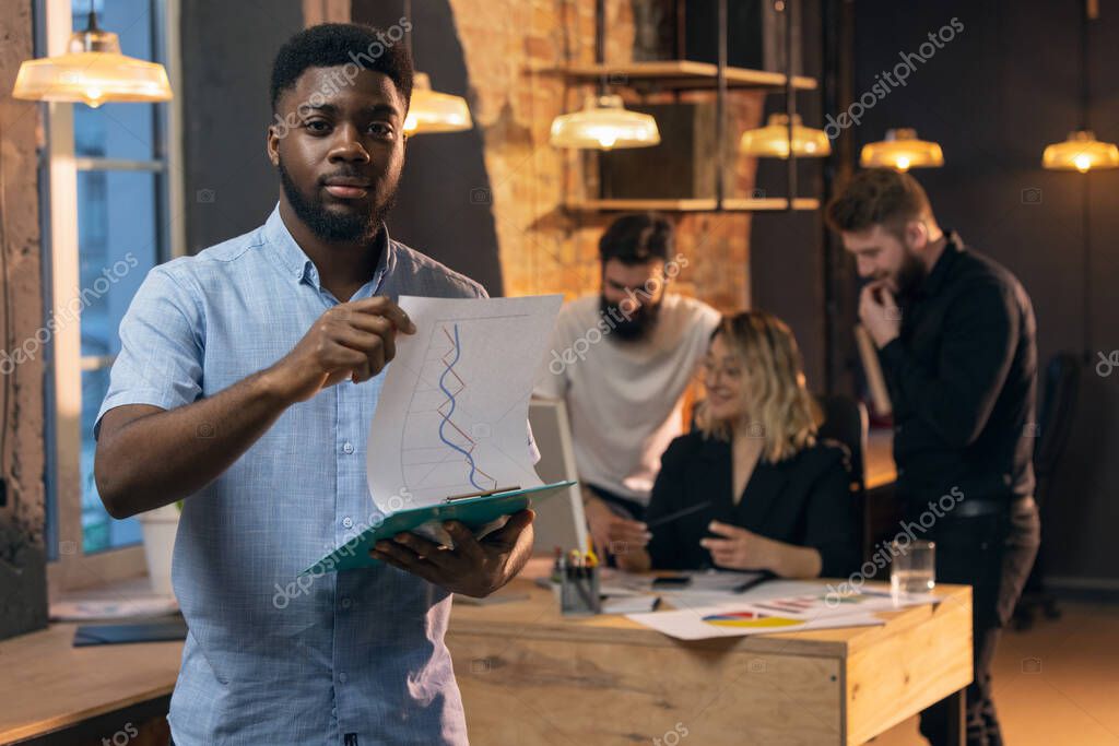 Colegas trabajando juntos en la oficina moderna utilizando dispositivos ...