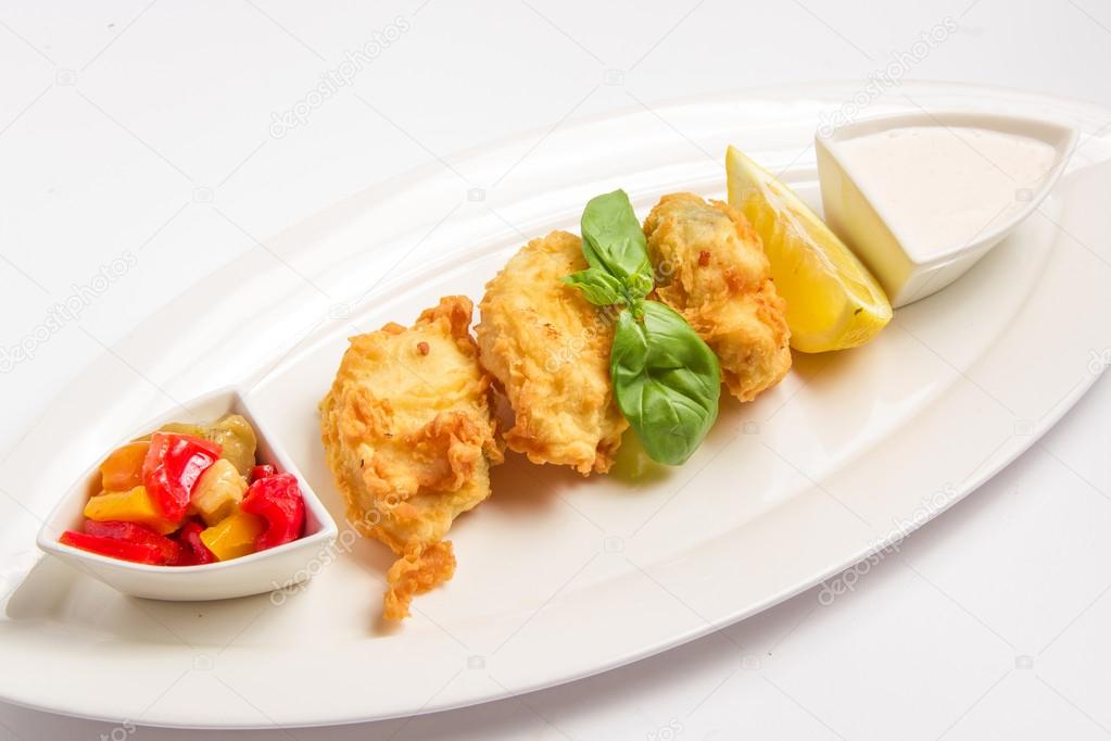 Fried fish in batter with sauce, lemon and vegetables Stock Photo by ...