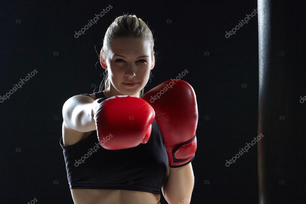 Beautiful woman is boxing on black background — Stock Photo ...
