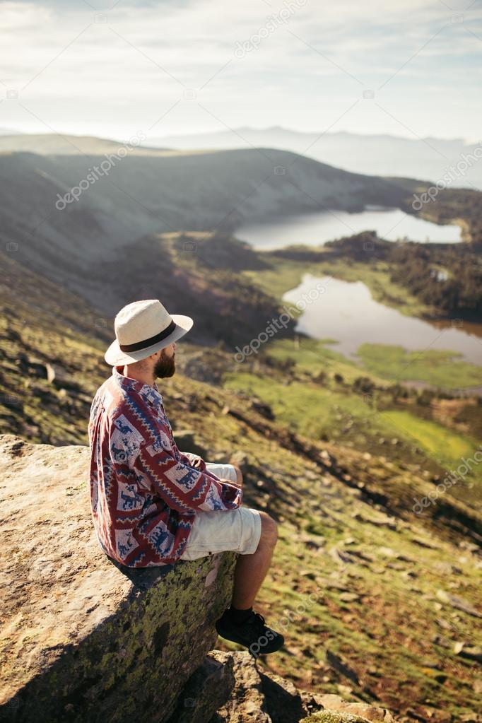 Hombre sentado en una roca mirando 2023