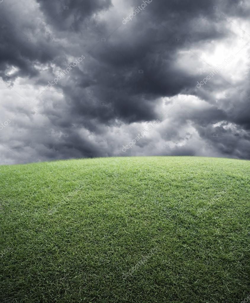 Campo de hierba verde con nubes de tormenta oscura antes de la lluvia 2024