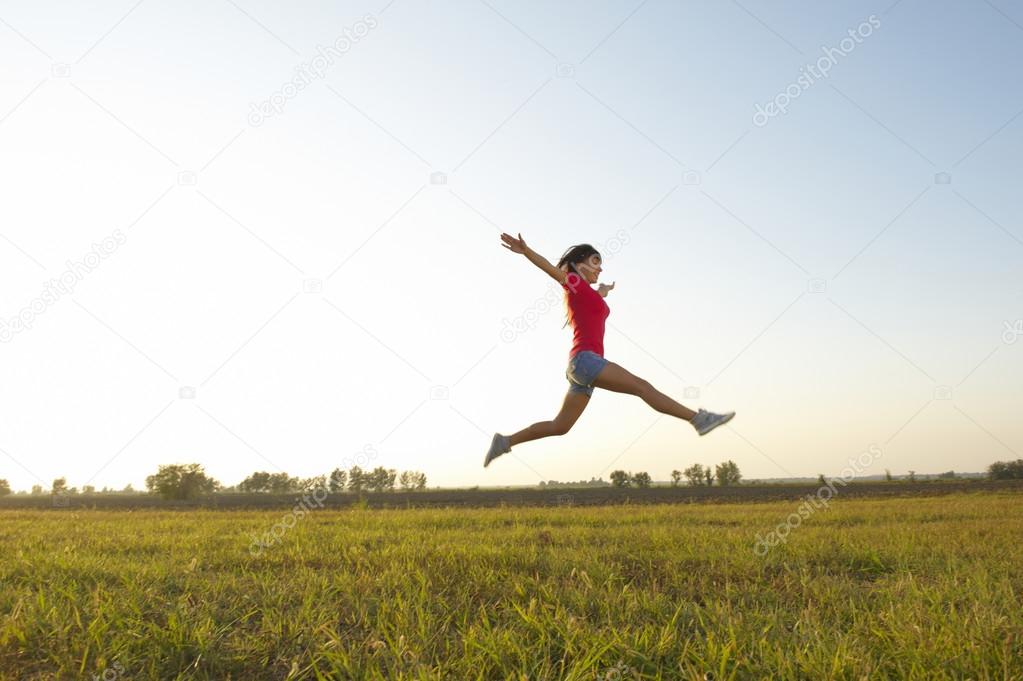 Chica saltando en el prado — Foto de stock #61112859 © nesharm