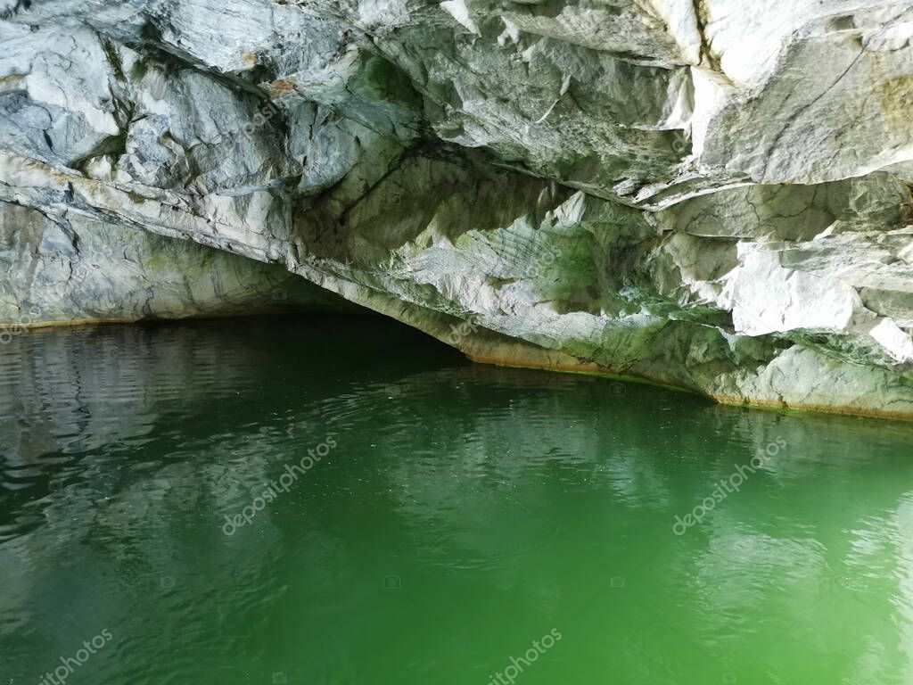 La pared de la gruta, reflejada en el agua esmeralda del Cañón del Mármol en el Ruskeala ...