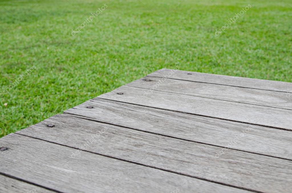 White wood table with green grass background — Stock Photo © kwanchaidp ...
