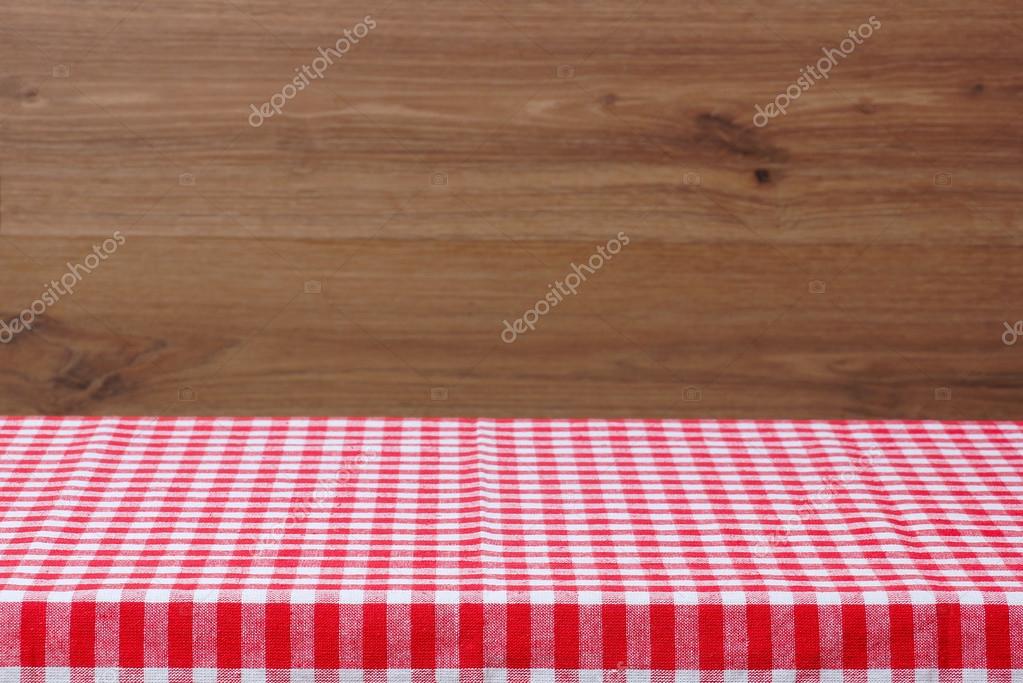 An empty table with a red checkered tablecloth. Wooden background ...