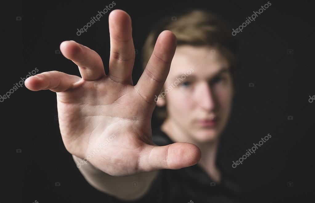 Image of a boy with his hand extended signaling to stop — Stock Photo ...