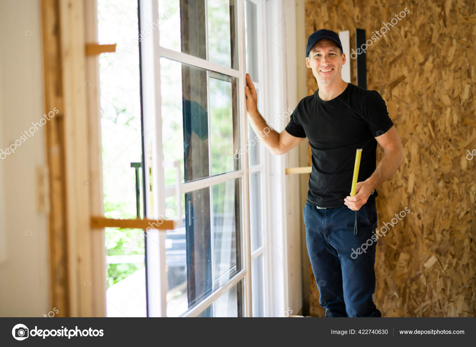 A handsome young man installing Double Sliding Patio Door in a new ...