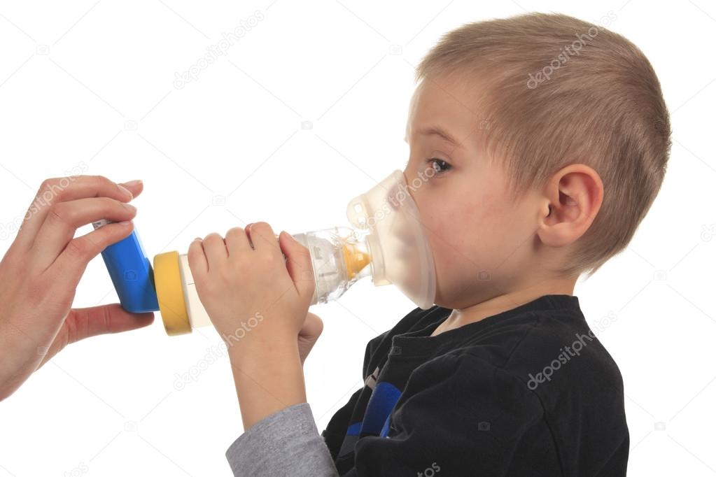 Close up image of a cute little boy using inhaler by himself for asthma ...