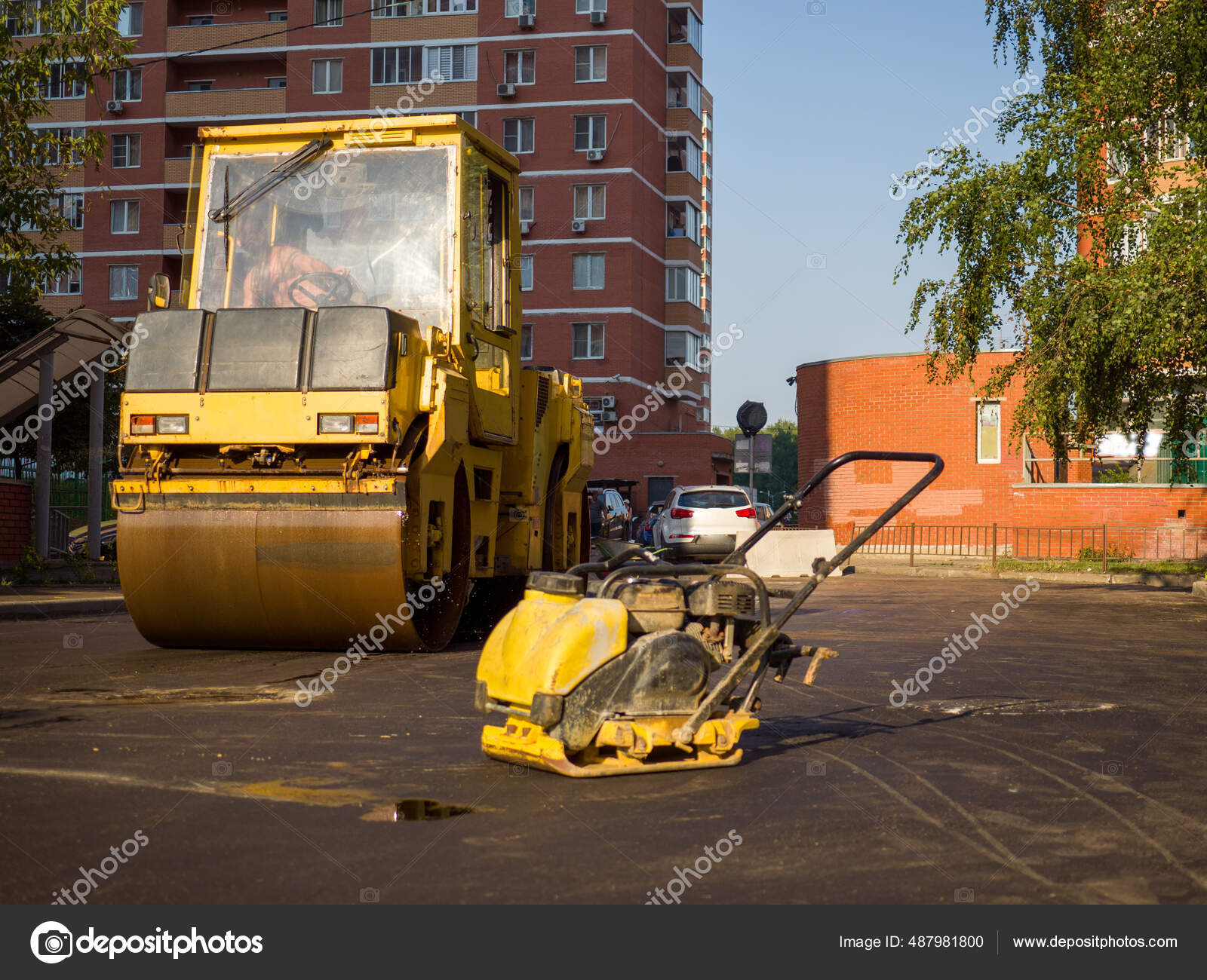 Laying new asphalt. Single direction Vibratory Plate In the foreground ...