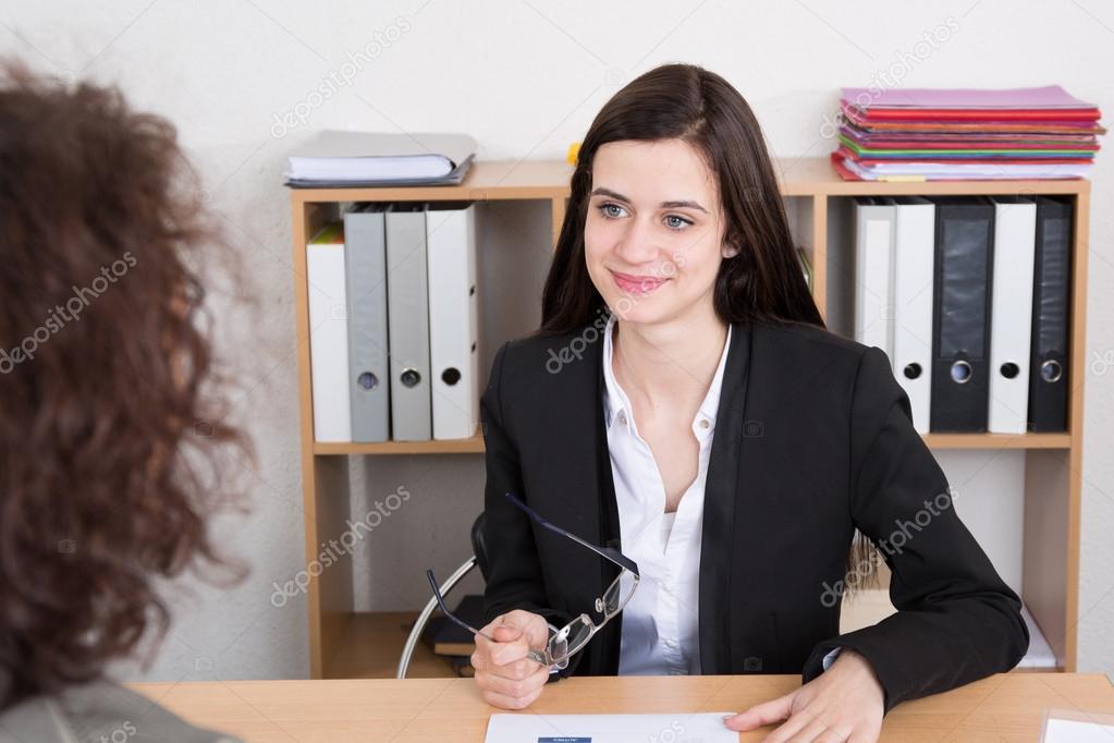 Beautiful young businesswoman conducting a job interview seated at her ...