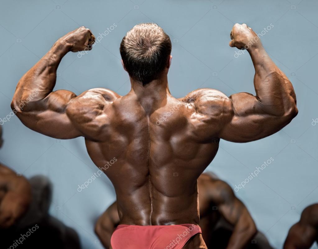 Mans back double biceps pose. Stock Photo by ©Denisfilm 104746480