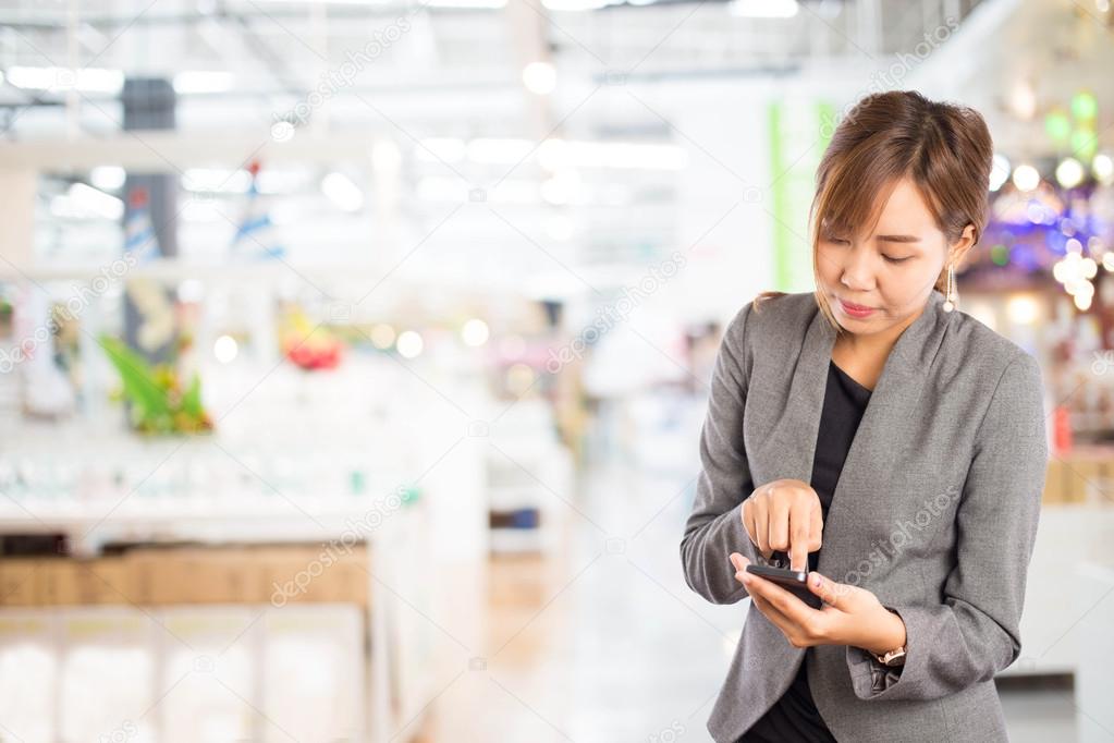 Women in shopping mall using mobile phone. Stock Photo by ©pat194 86519018