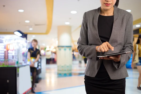 Women in shopping mall using mobile Tablet PC. - Stock Image - Everypixel
