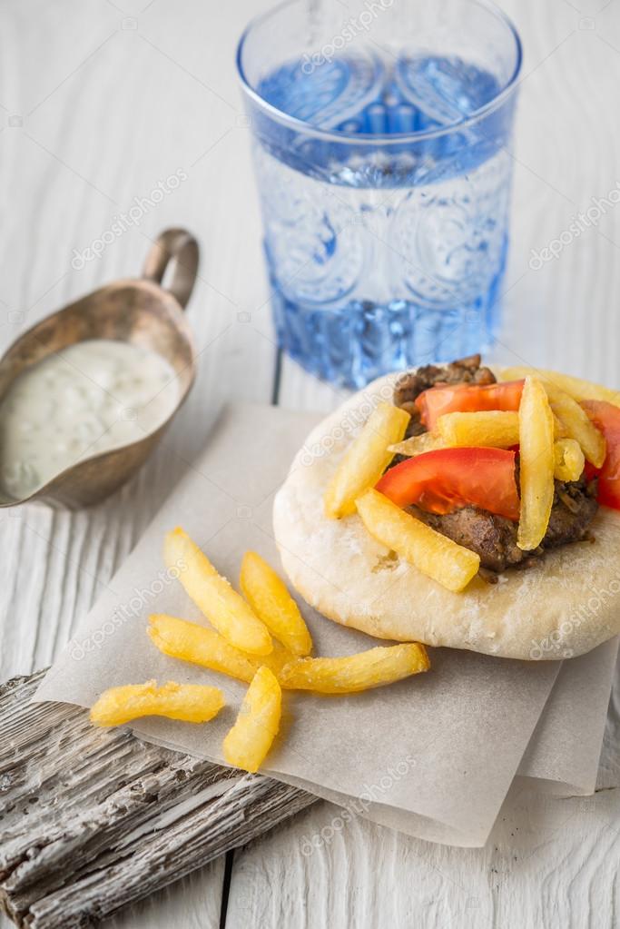 Gyros with potatoes, meat, tomato on pita bread, stand and dzatz Stock ...