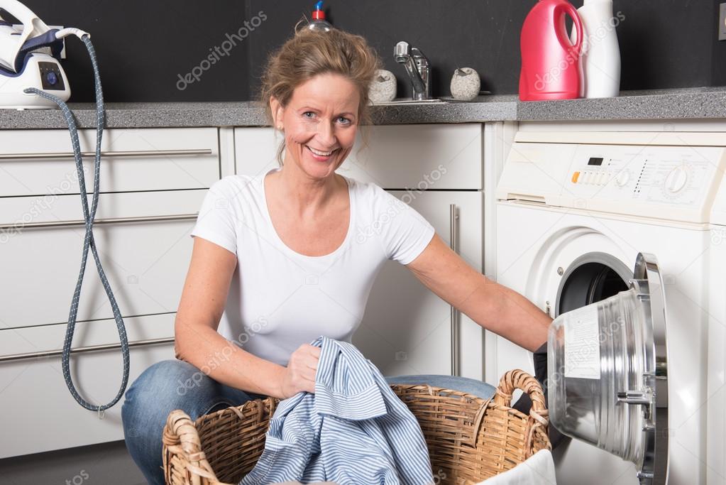 Woman loading washing machine — Stock Photo © JHRSPhotos #65408867
