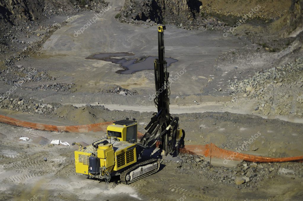 A yellow industrial machine working on a quarry — Stock Photo ...
