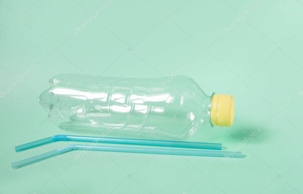 Botella de pl stico desechable y paja sobre fondo verde, concepto ecol ...