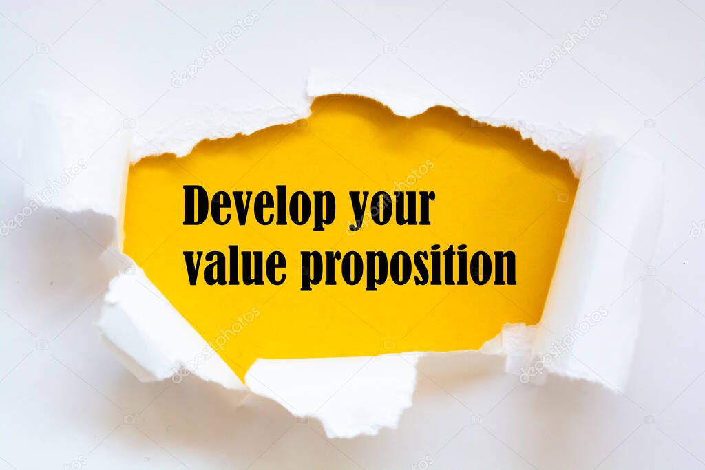 Desarrolla tu eslogan de propuesta de valor escrito bajo papel roto ...